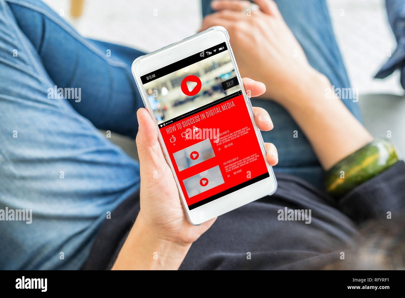 Top view woman watching video online with advertising on mobile on sofa ...