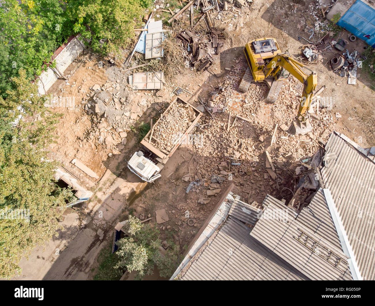 aerial view of demolition site with half ruined old building, yellow ...
