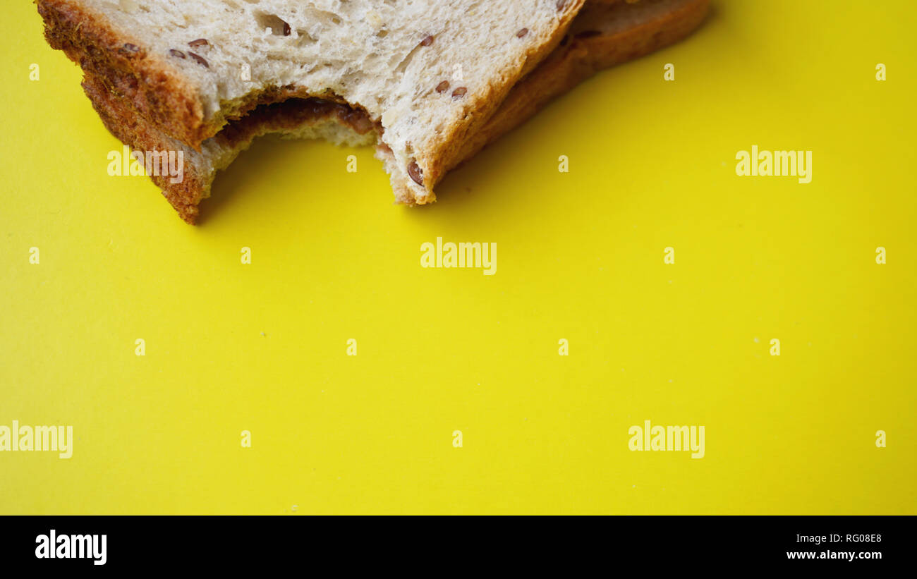 Bitten Toast on yellow background. View from above - Copy space ...