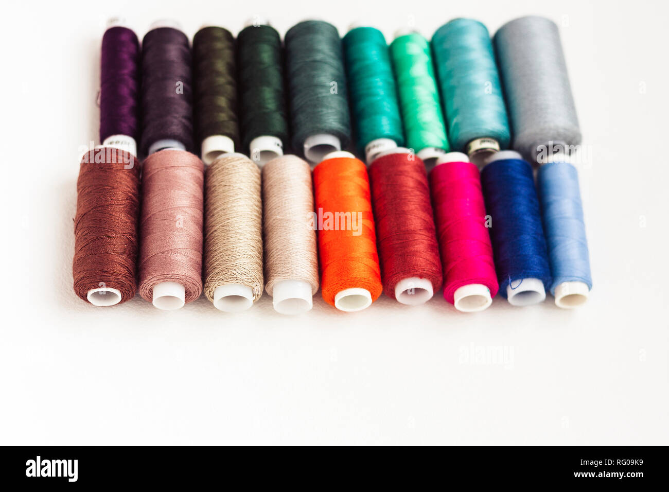 Colored sewing thread coils on white background with copy space for ...