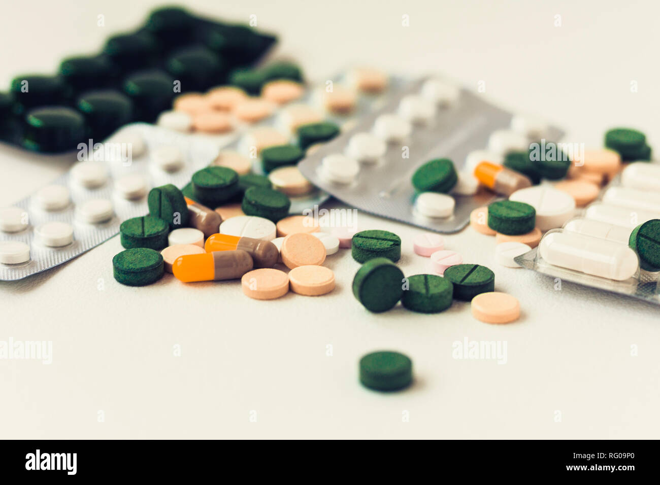 Medicine green, pink and yellow pills or capsules on white background ...