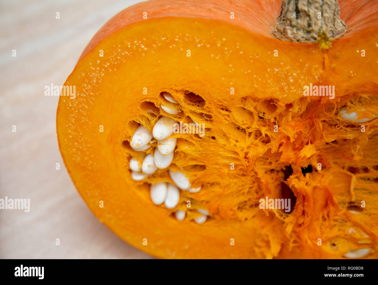 Half a juicy bright and ripe pumpkin in the cut with a stem and seeds ...