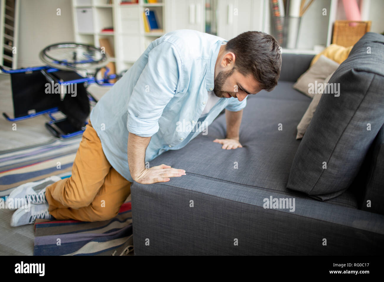 Young man falling on sofa hi-res stock photography and images - Alamy