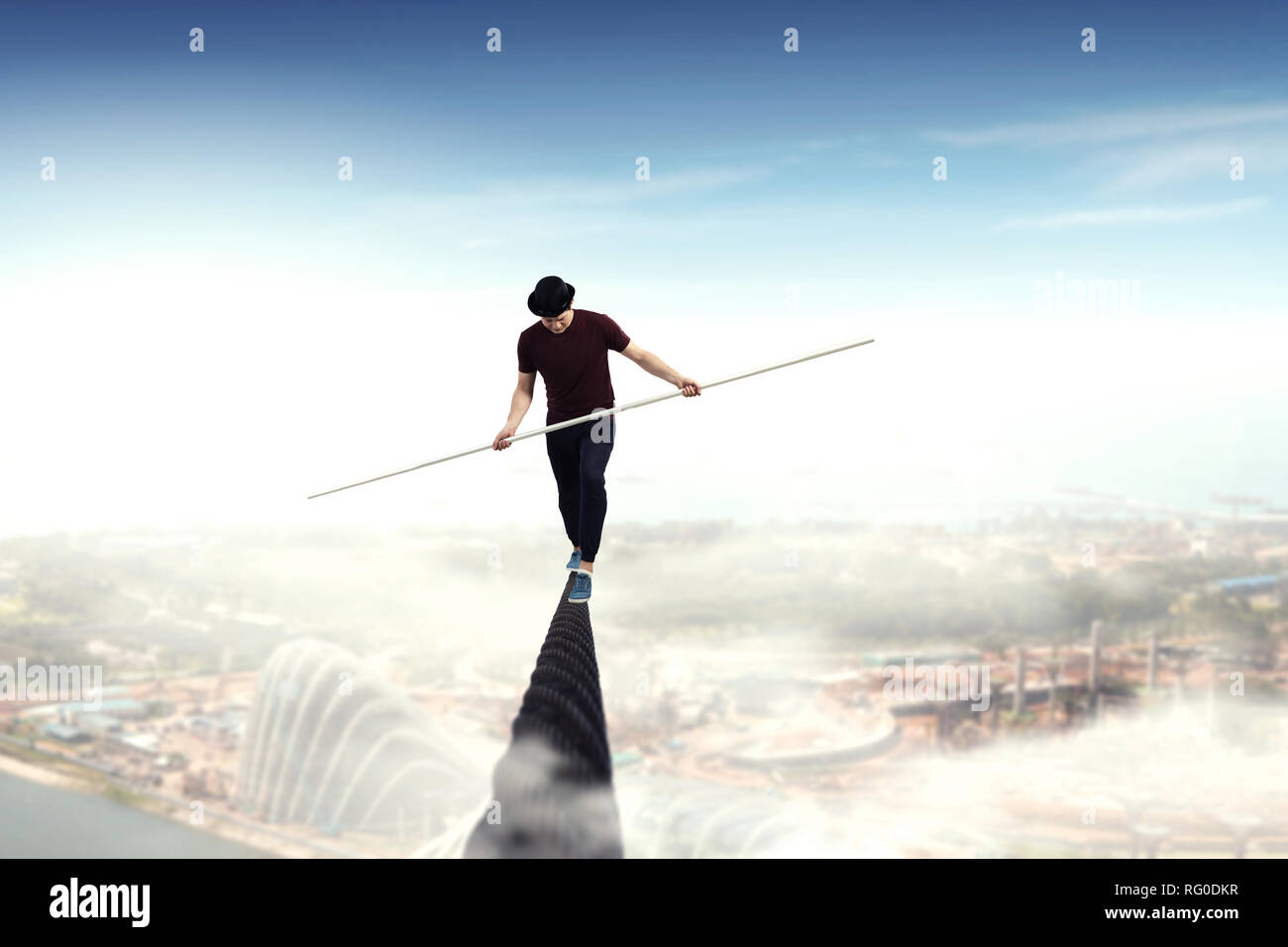 Ropewalker in black hat walking rope high in sky . Mixed media Stock ...