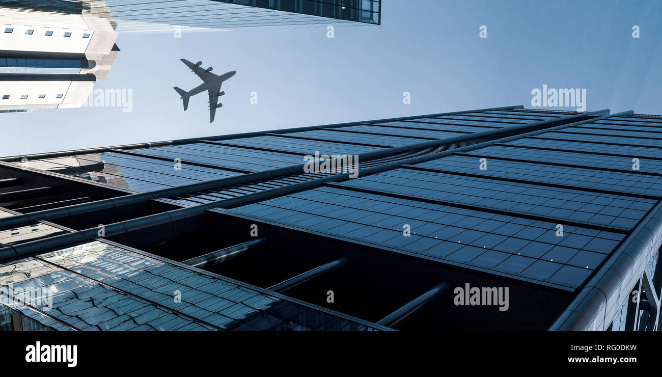 Bottom angle view of airplane in sky over city buildings Stock Photo ...