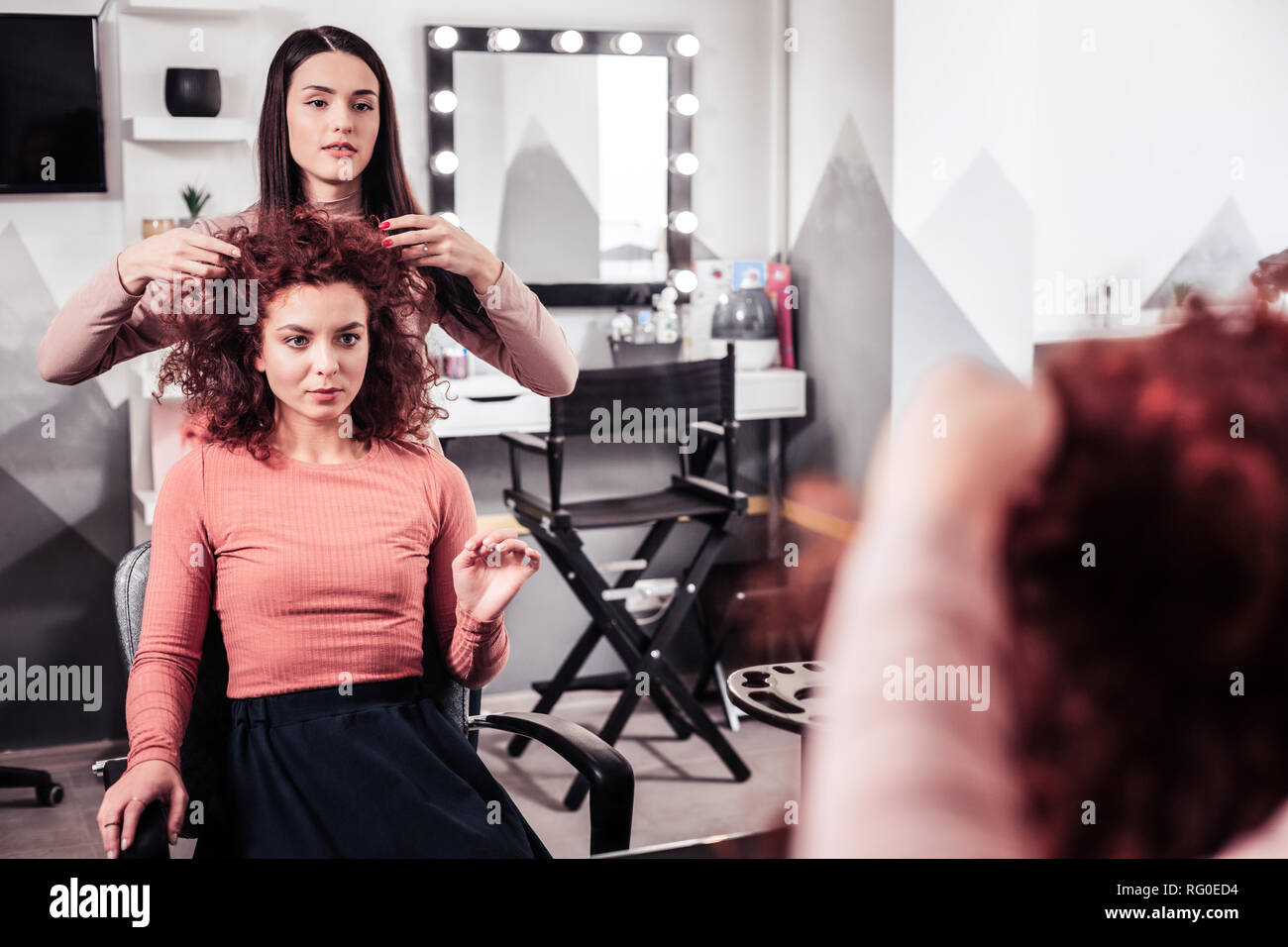 Nice young woman looking at her mirror reflection Stock Photo - Alamy