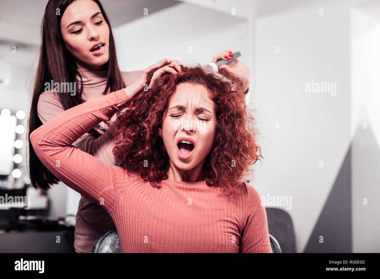 Unhappy red haired woman screaming from pain Stock Photo - Alamy