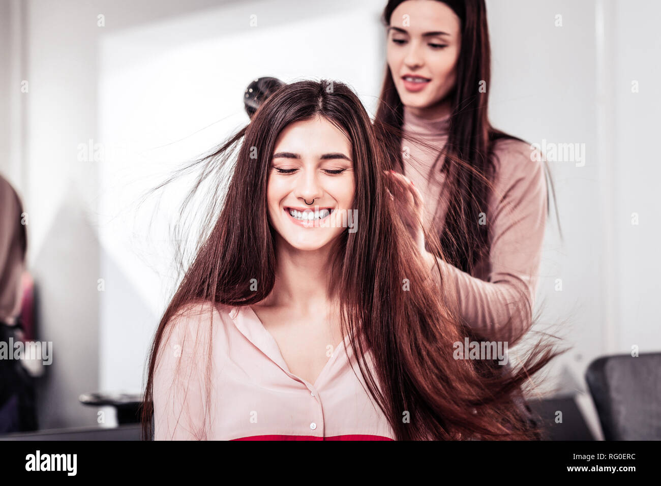 Delighted good looking young woman closing her eyes Stock Photo - Alamy