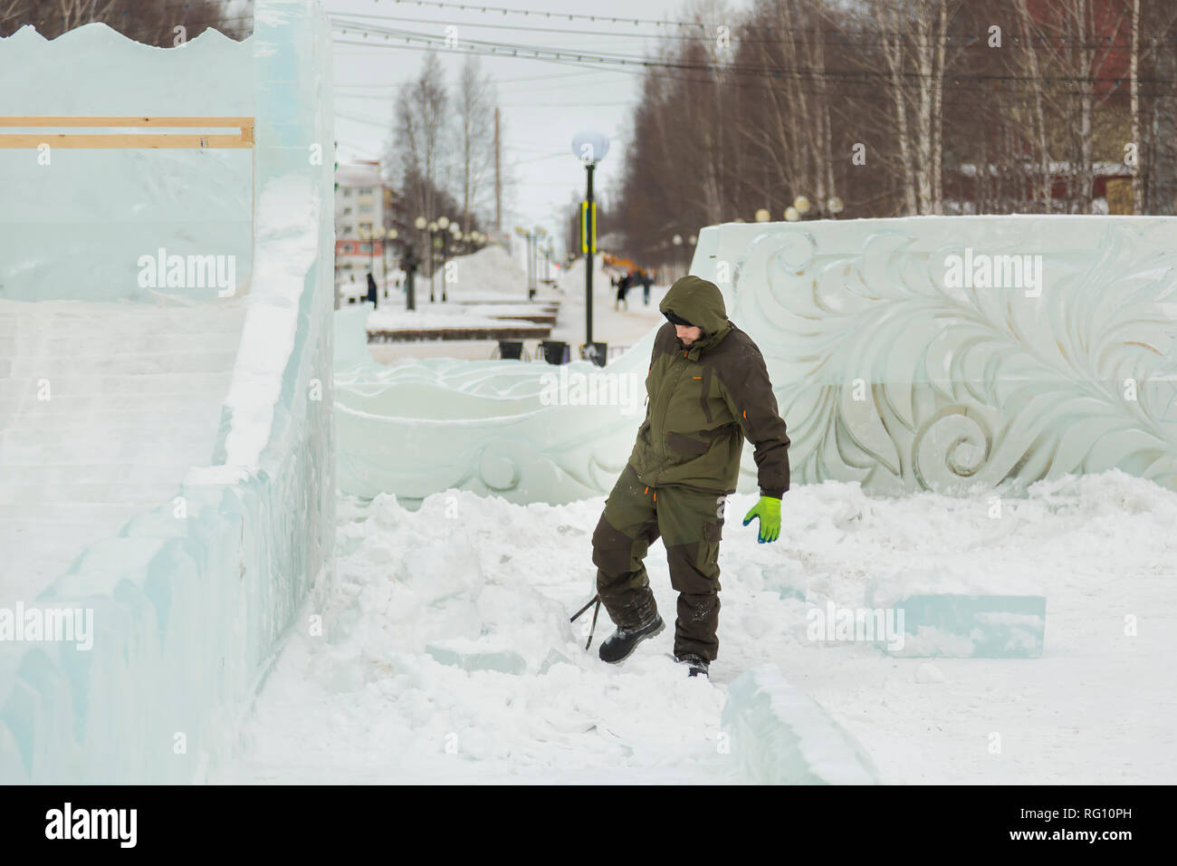 The worker pulls the ice block around the ice camp assembly site with ...
