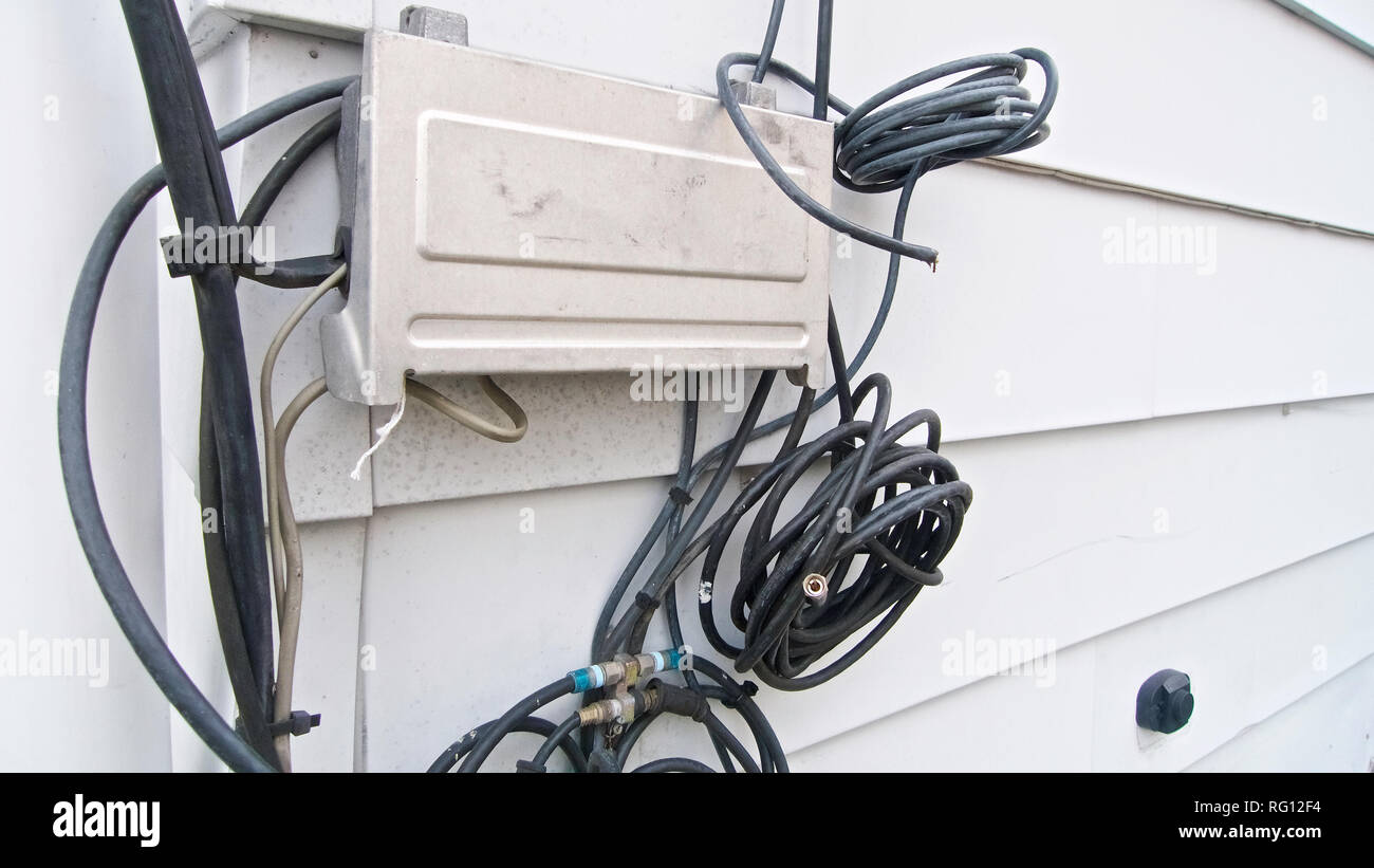 A telecommunications box installed and attached to the siding of a ...