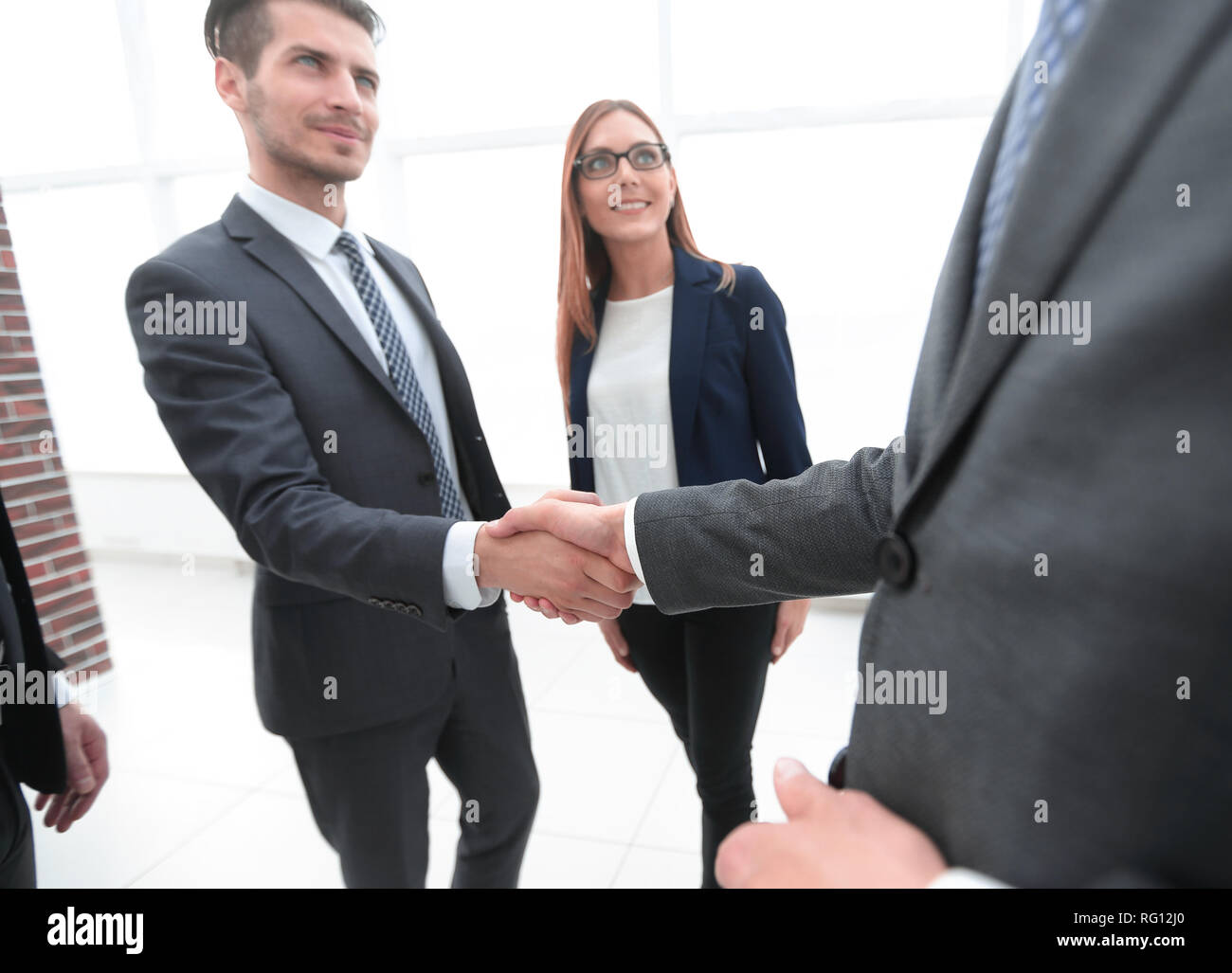 Business shaking hands in the office Stock Photo - Alamy