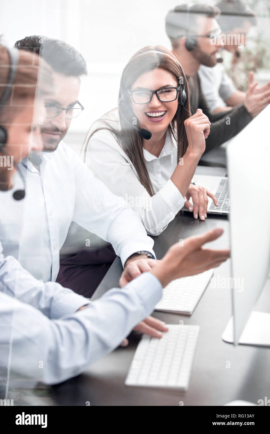smiling employees of call center talk sitting behind a Desk Stock Photo ...