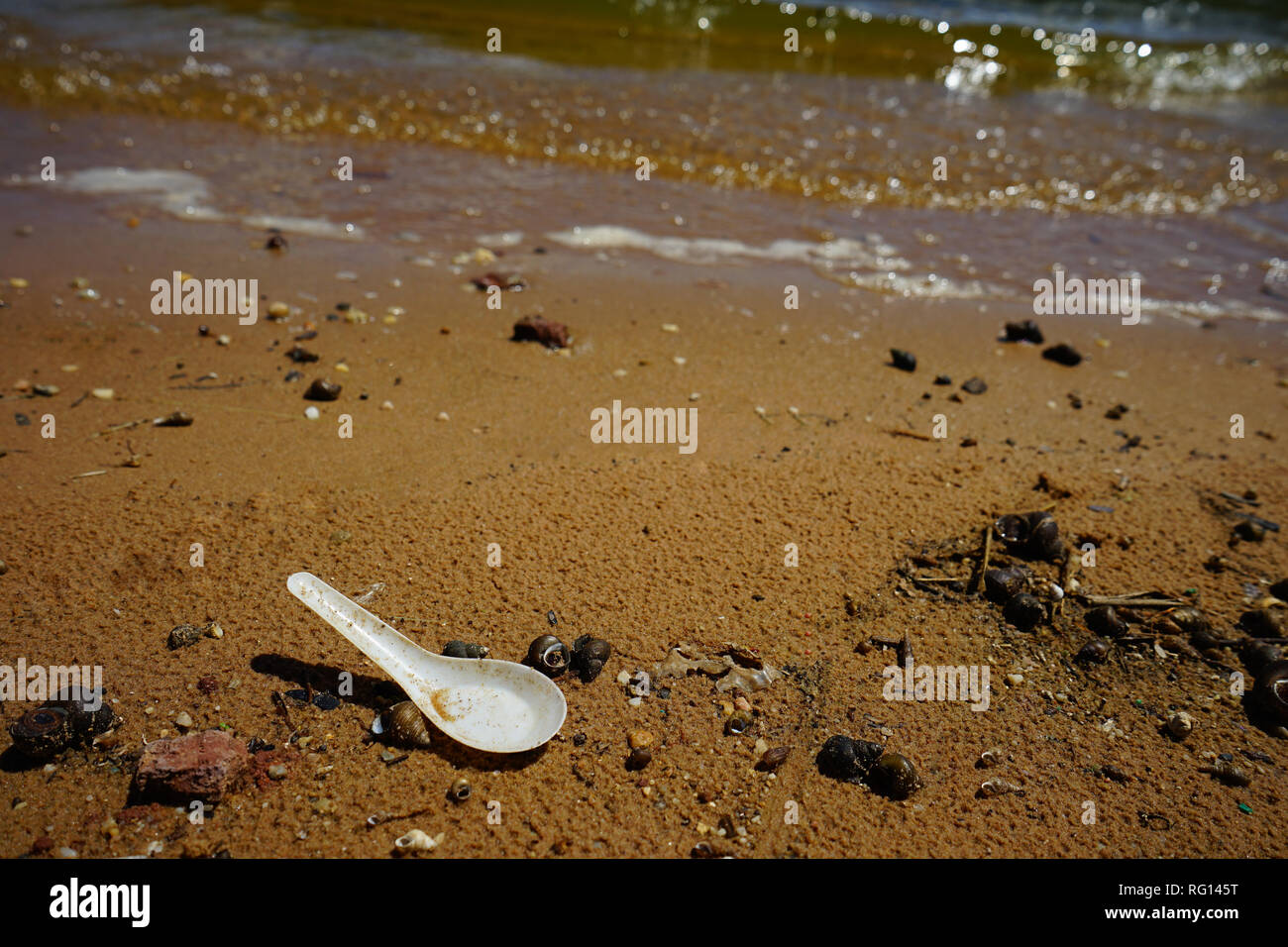 Broke plastic spoon on beach Stock Photo - Alamy