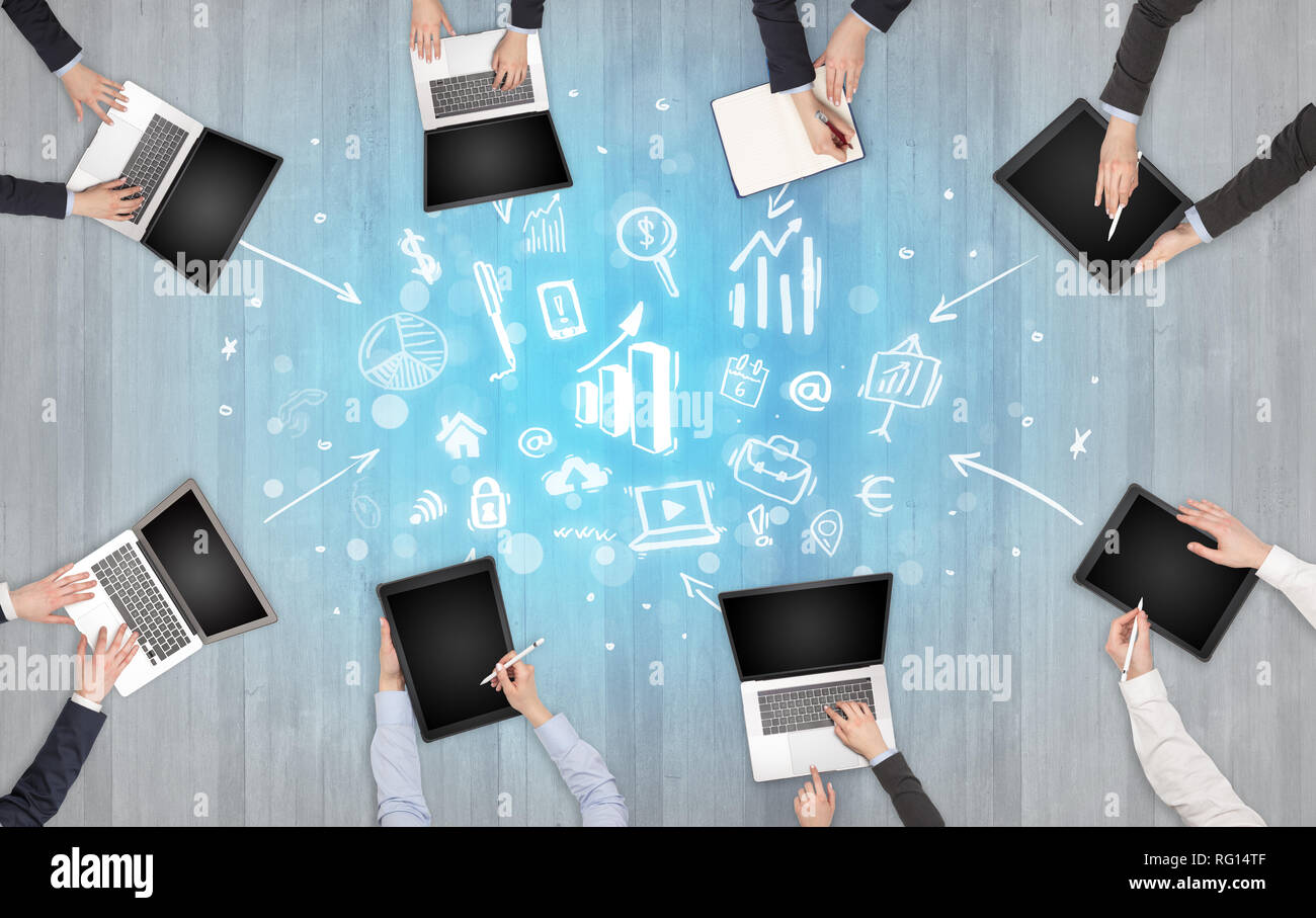 Group of people with devices in hands making reports together on laptop ...