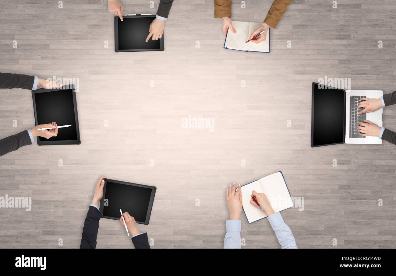 Group of people with devices in hands having desk discussion and making ...
