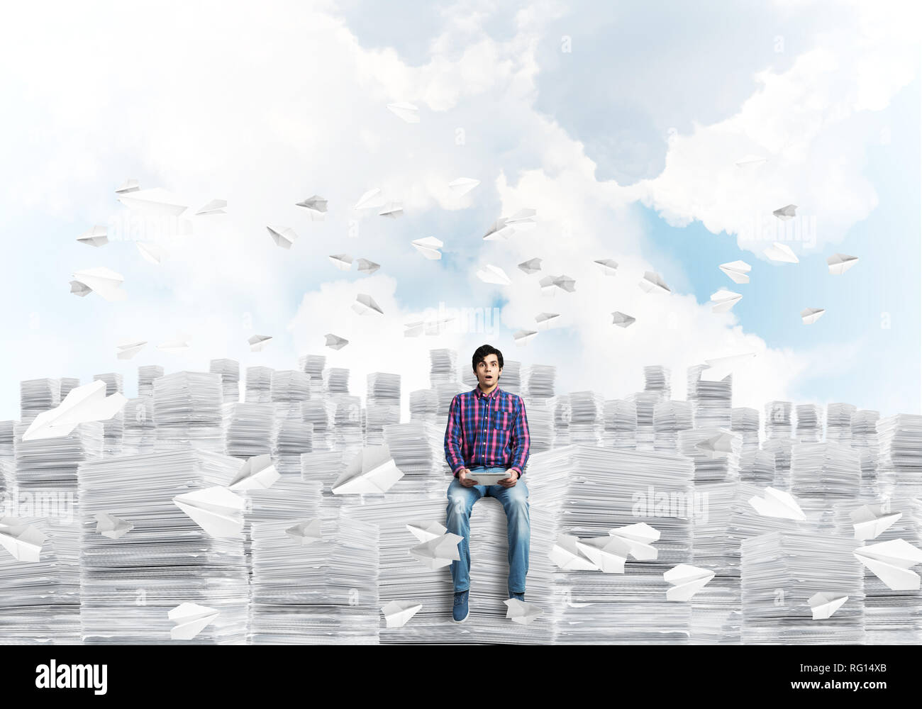 Attractive man sitting on pile of paper documents Stock Photo - Alamy