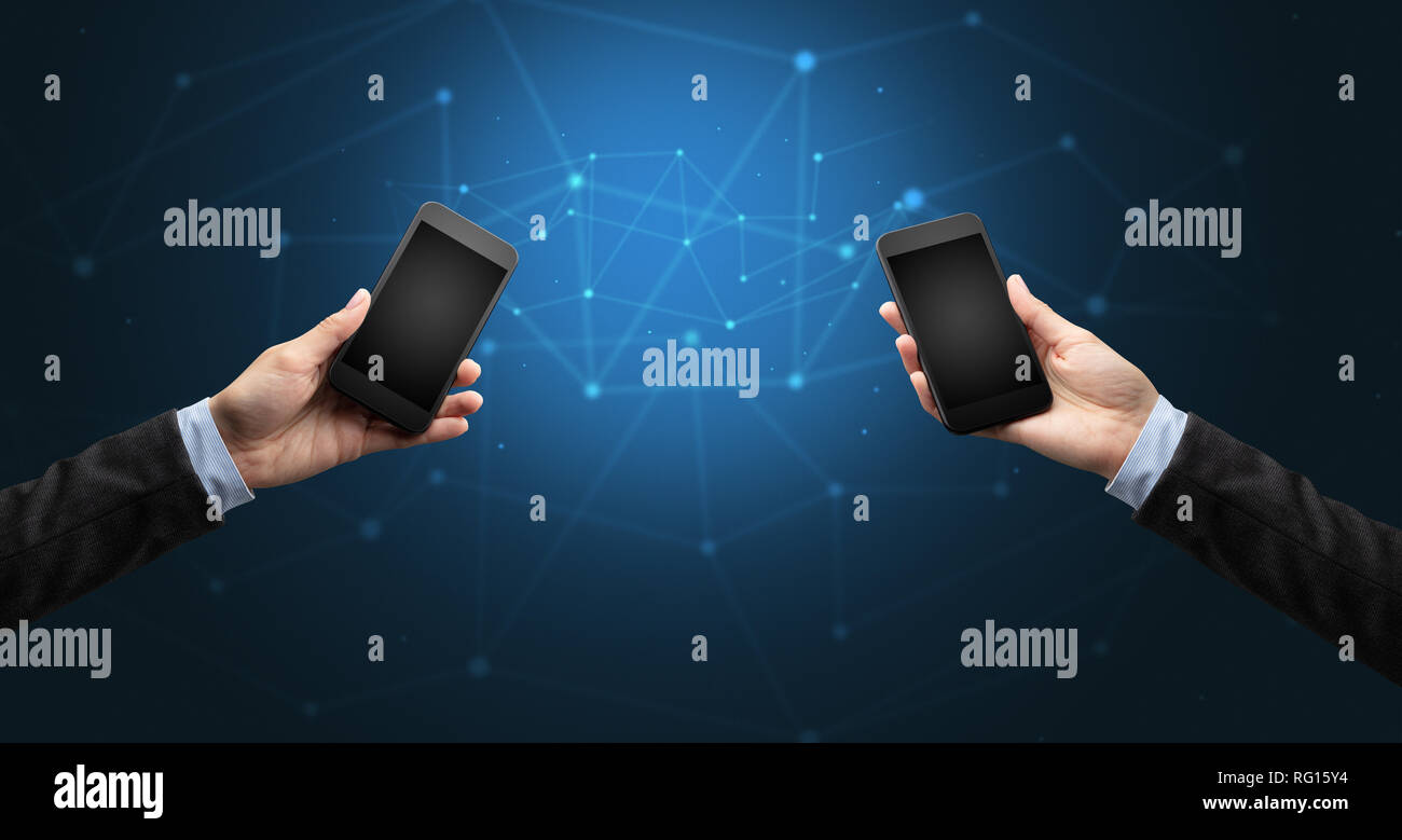 Close up of two hands holding smartphones to each other, wireless ...