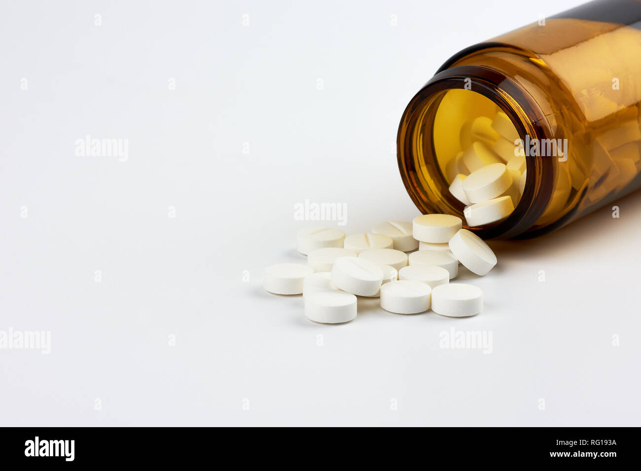 Close-up view of pills and medication sprinkled from a brown vial on ...