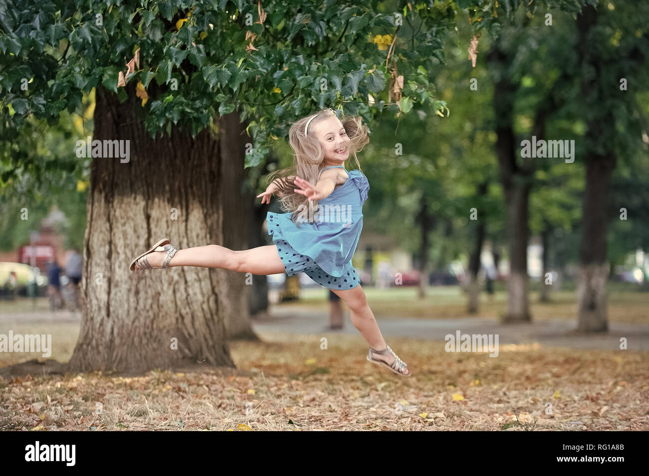 Little girl dancer jump in summer park. Child dance in blue dress ...