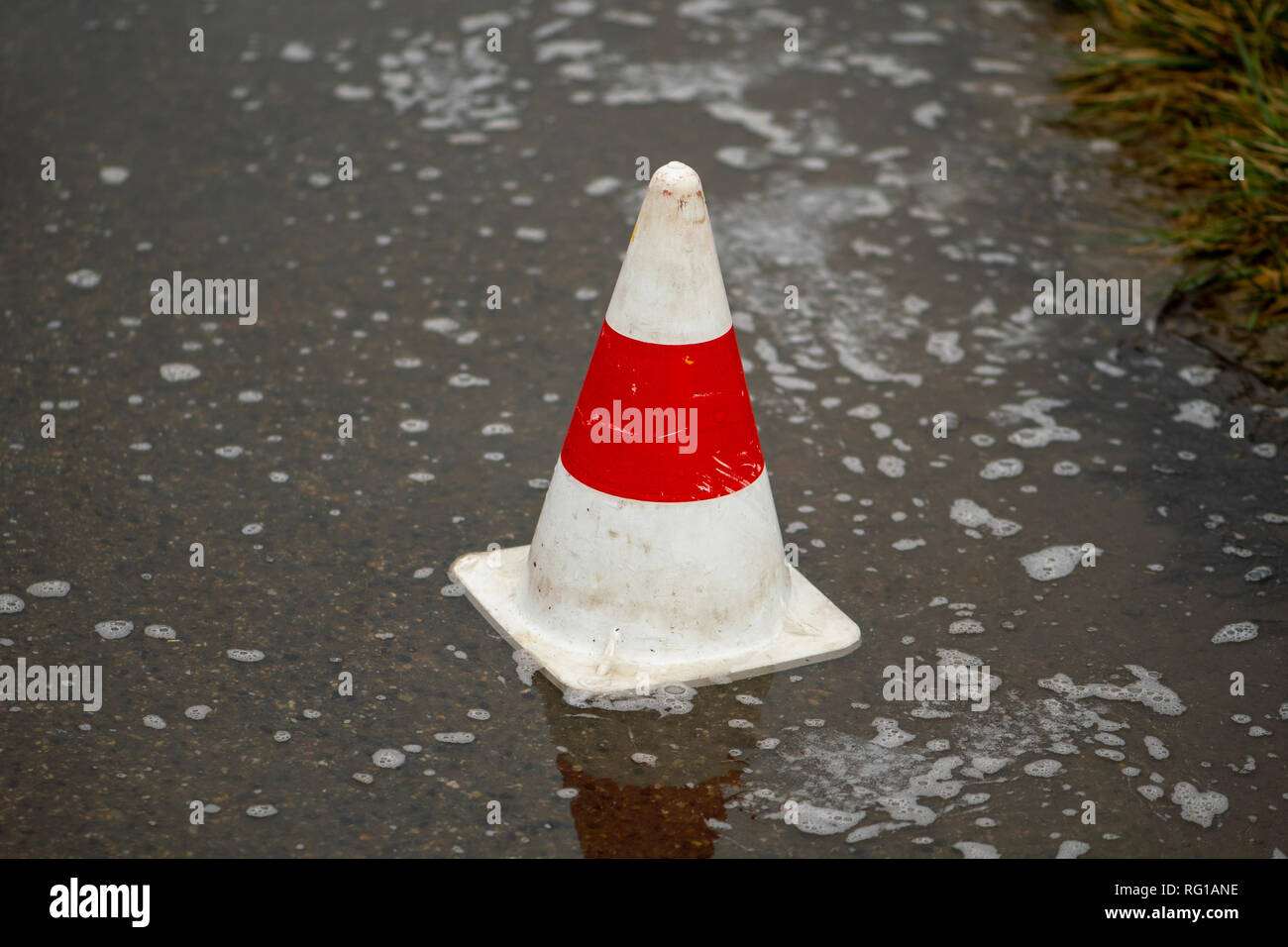 Pilone on the road in a puddle of rain Stock Photo - Alamy