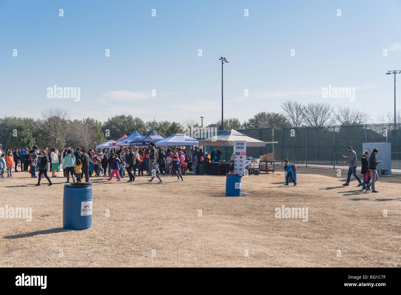Diverse group of people queue in line to attend outdoor winter festival ...