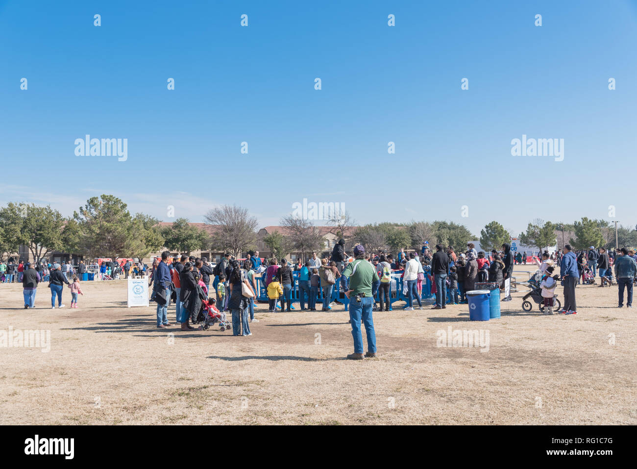 Diverse group of people queue in line to attend outdoor winter festival ...
