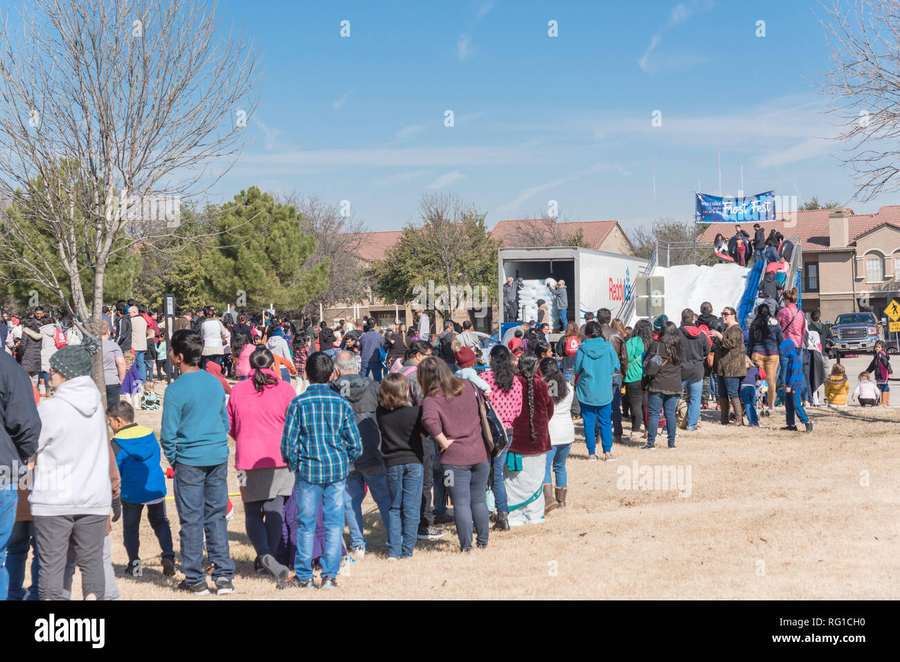 Diverse group of people queue in line to attend outdoor winter festival ...