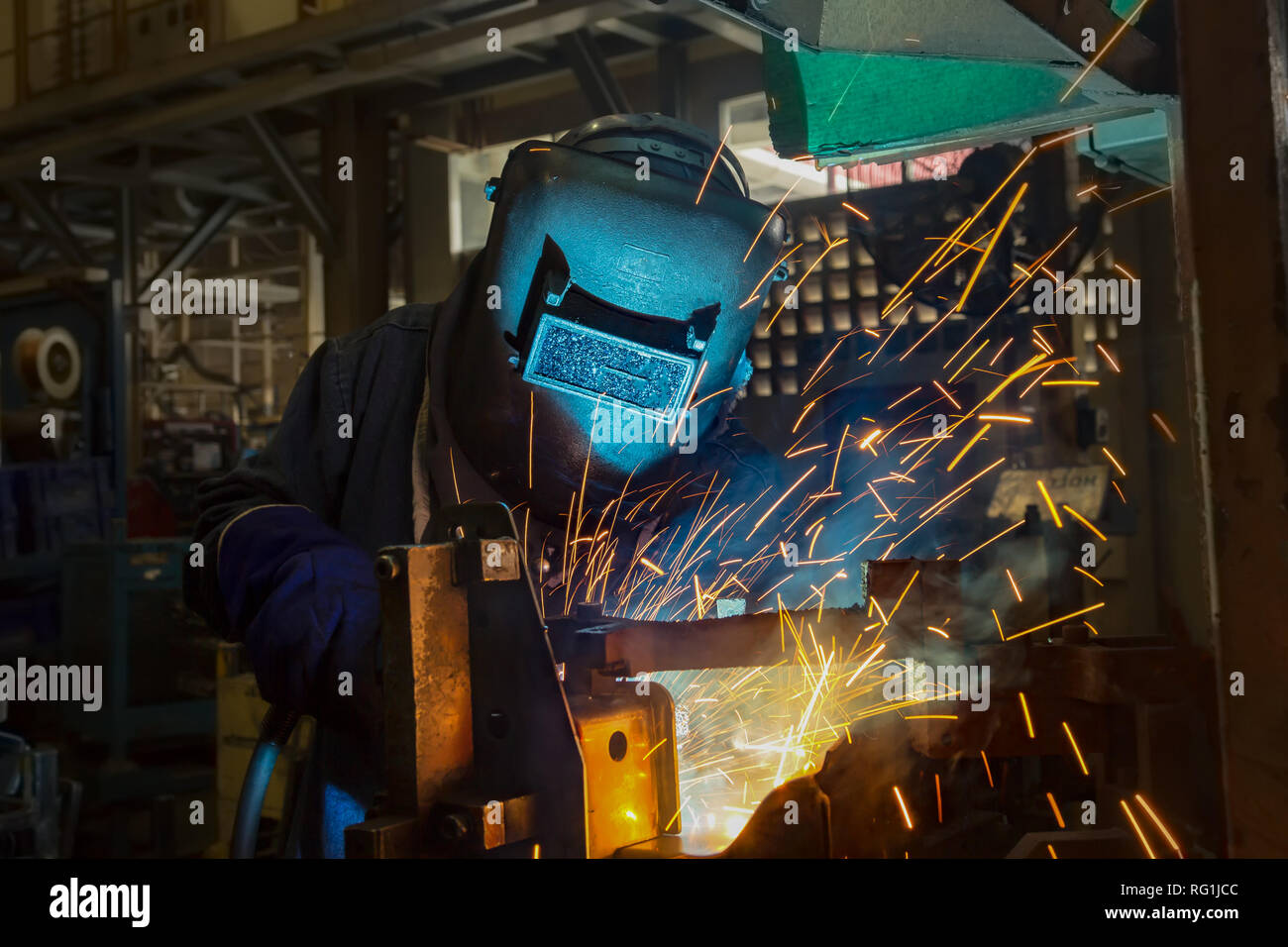 Industrial worker is welding metal in factory Stock Photo - Alamy