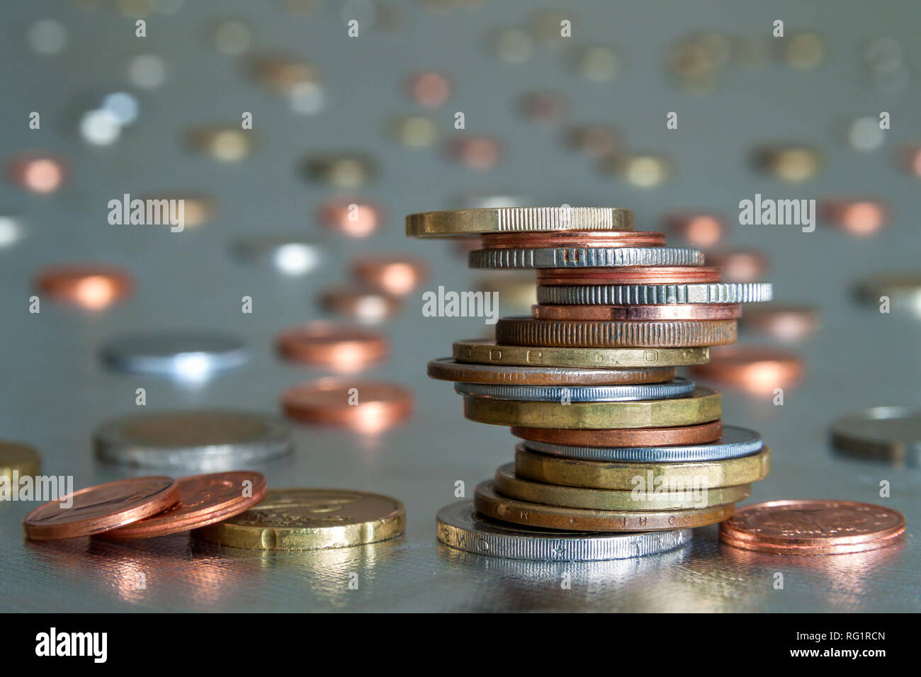 Pile of shiny coins different sizes and colors stacked unevenly on each ...