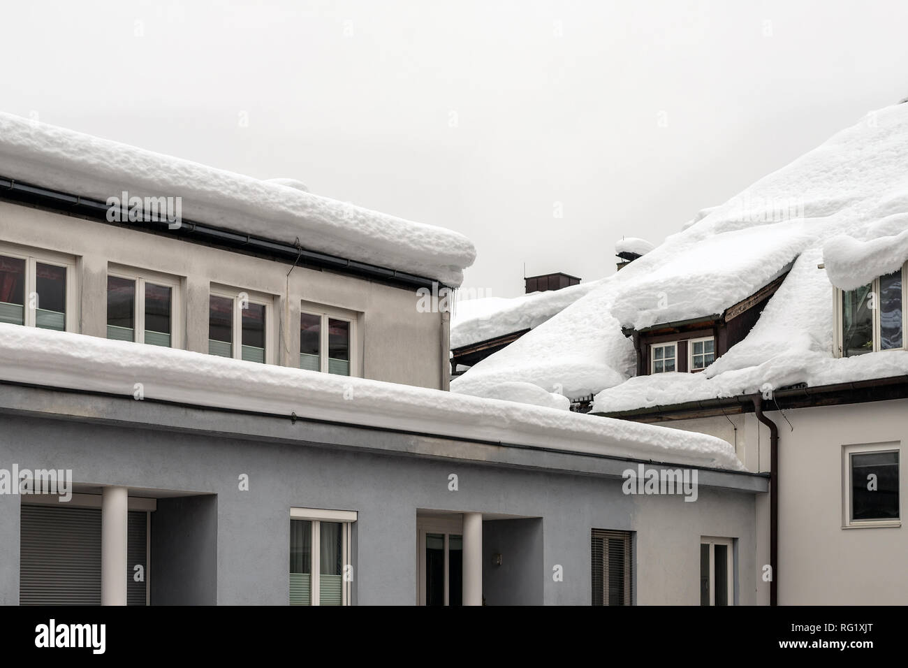 Roof of building with window and thick snow layer in winter. Snowfall ...