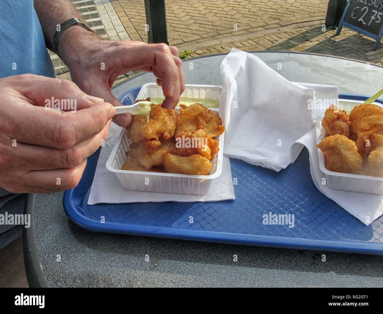 Two plastic cartons with fried fish with sauce Stock Photo - Alamy