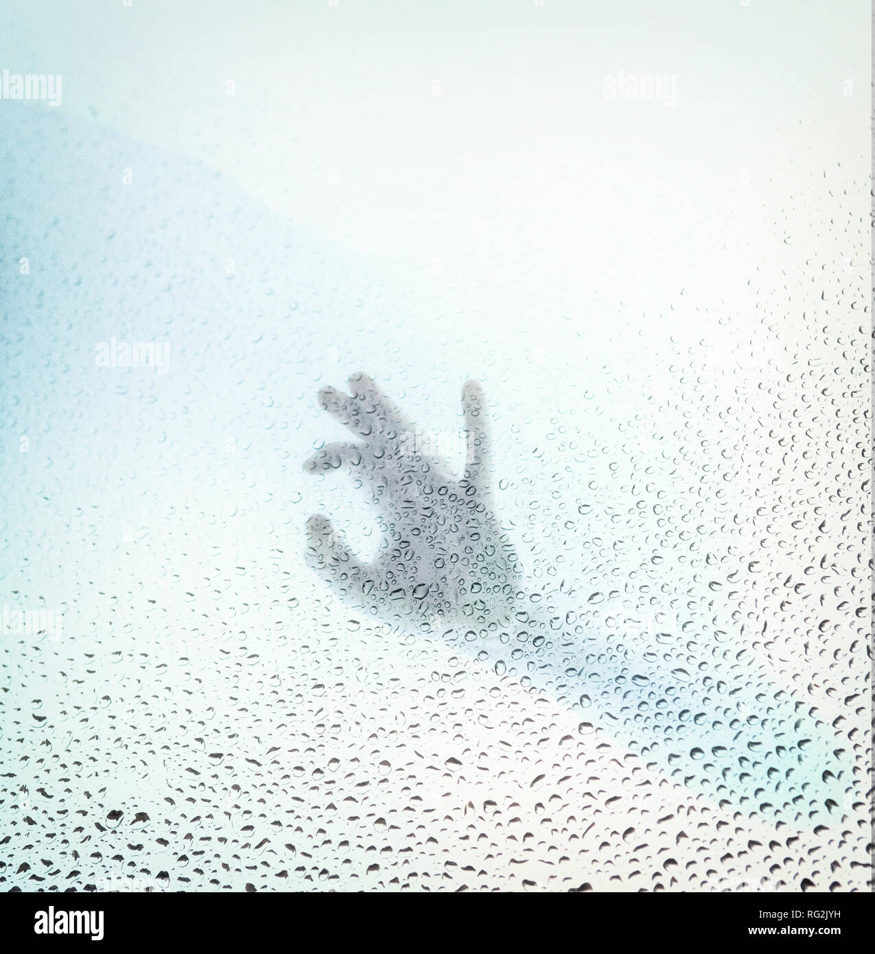 Hand behind glass with water drops Stock Photo - Alamy