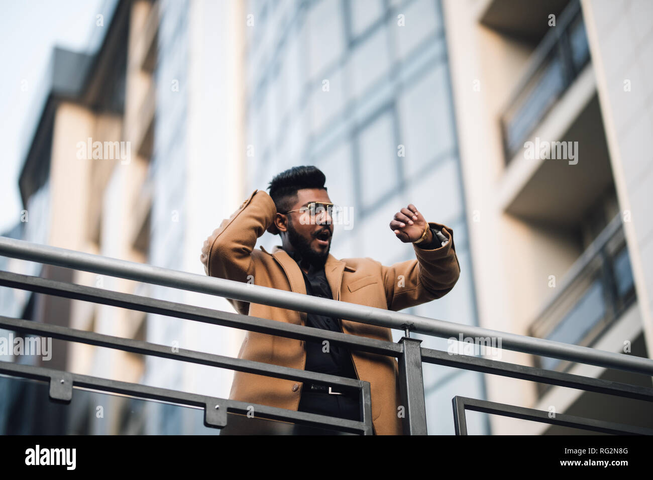 Portrait handsome indian business man looking smart watch and shocked ...