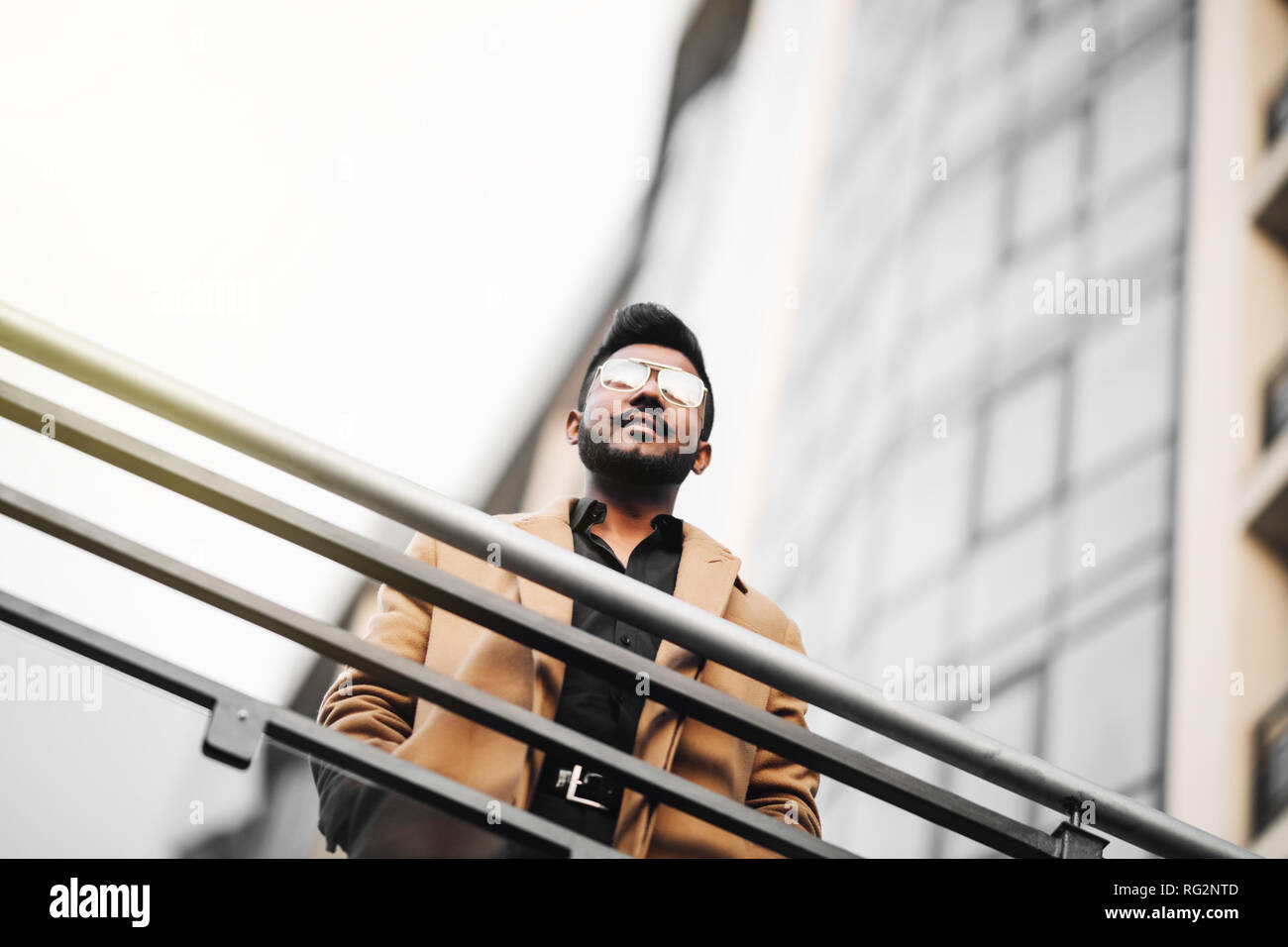 Low angle view of happy young businessman standing in front of office ...