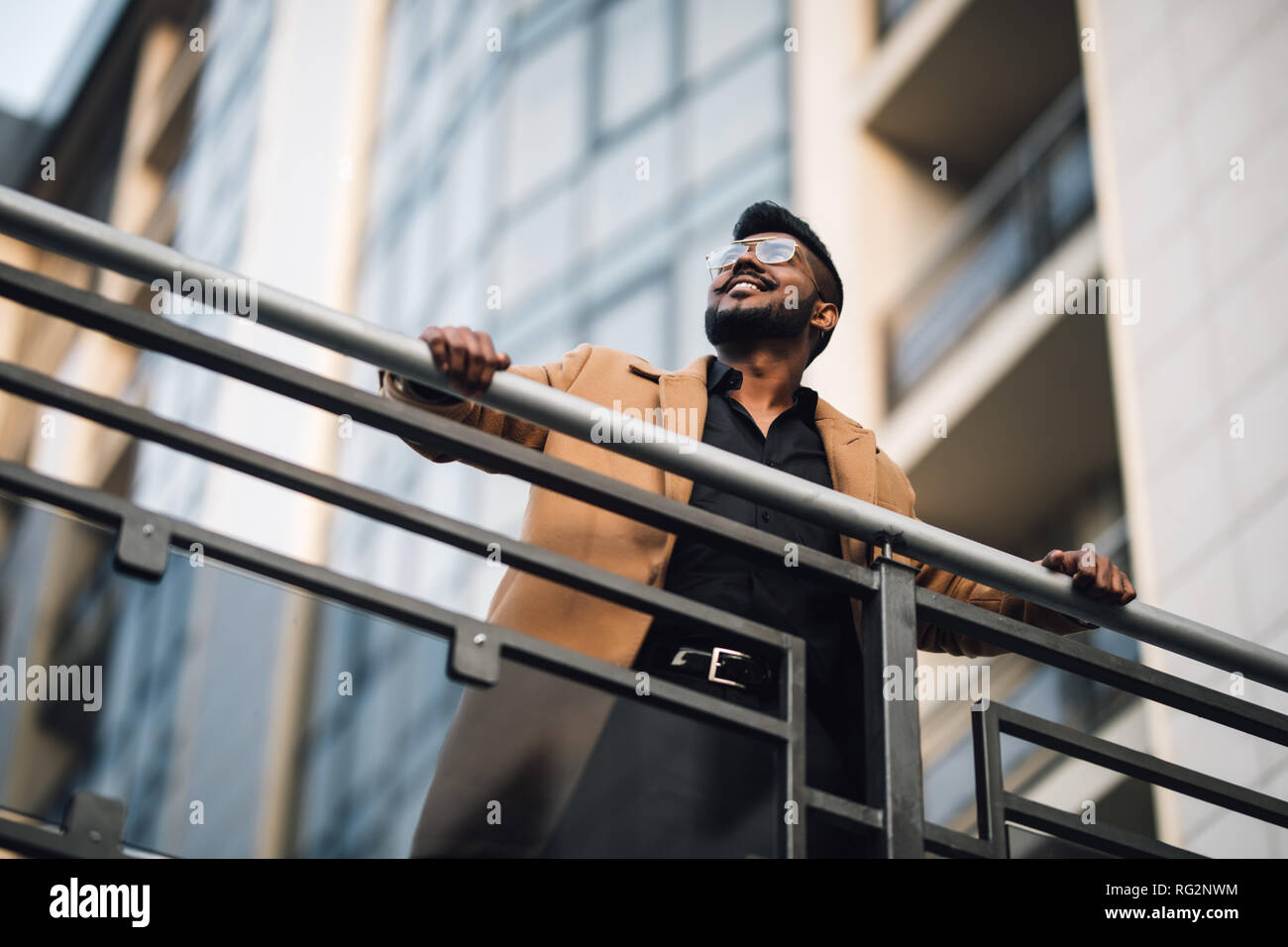 Low angle view portrait of a indian man wearing sunglasses and jacket ...