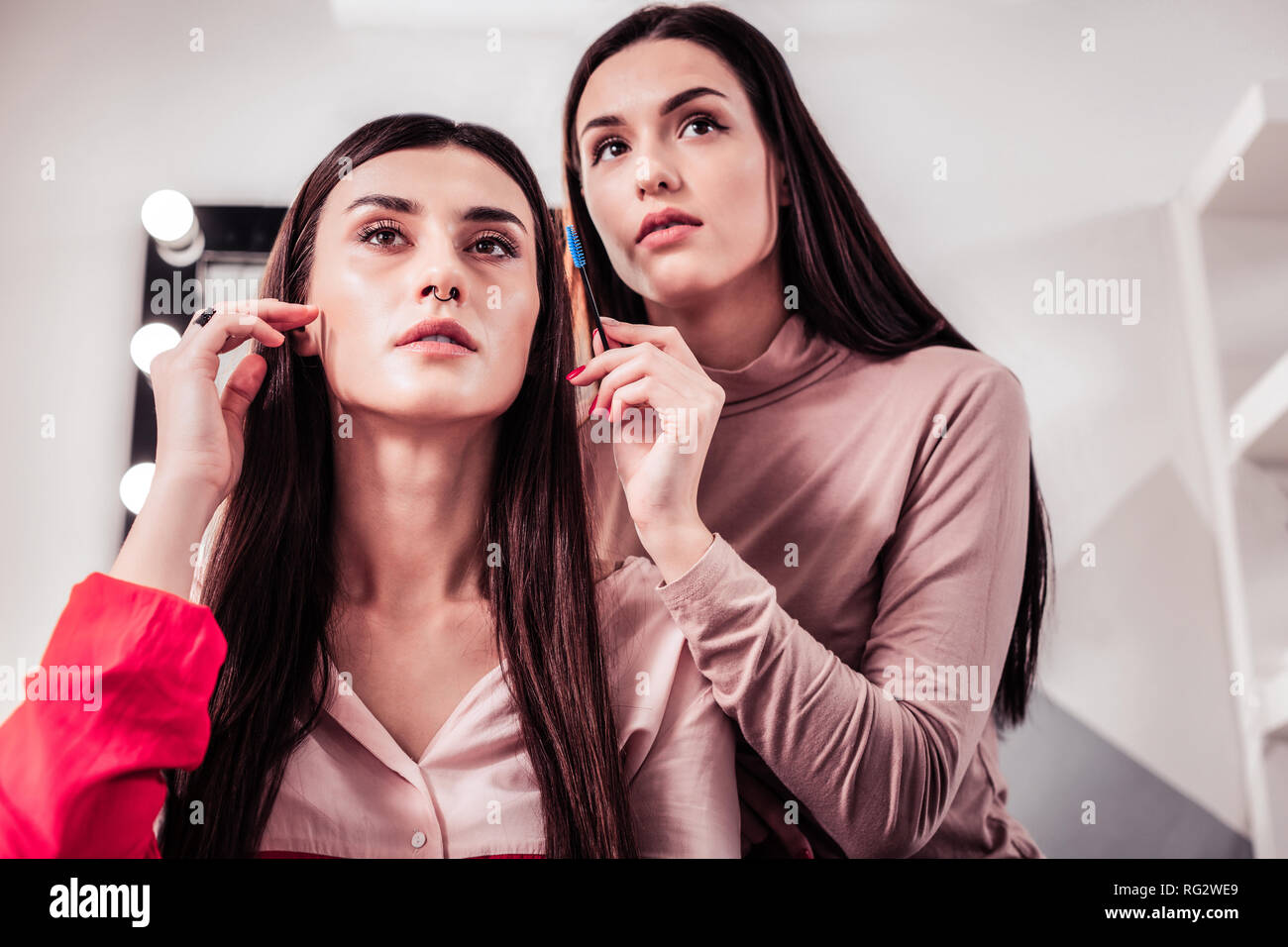 Beautiful nice woman looking at her face Stock Photo - Alamy