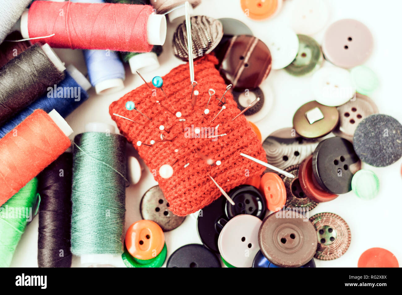 Red knitted needle pad for sewing, sewing buttons and colored thread ...