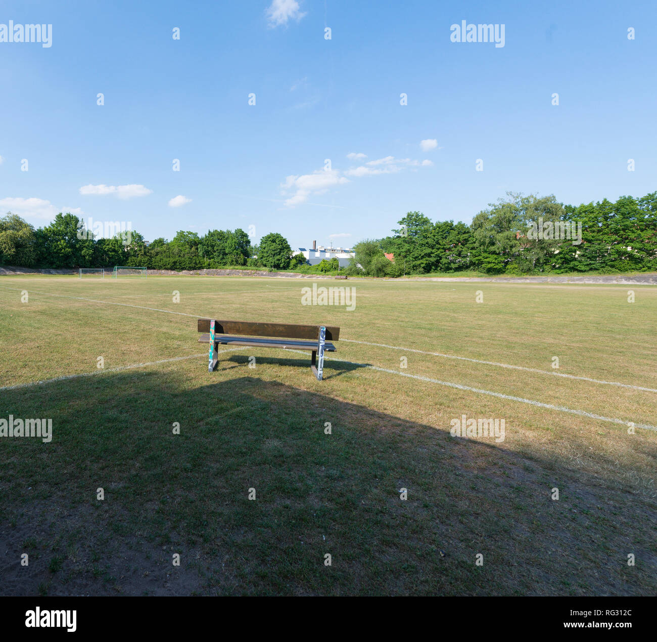 soccer field with old bench and trees with blue sky Stock Photo - Alamy