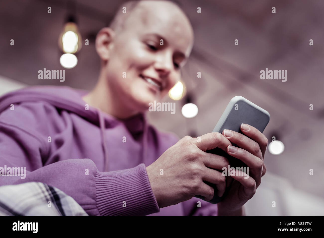 Cheerful bold woman keeping smile on her face Stock Photo - Alamy