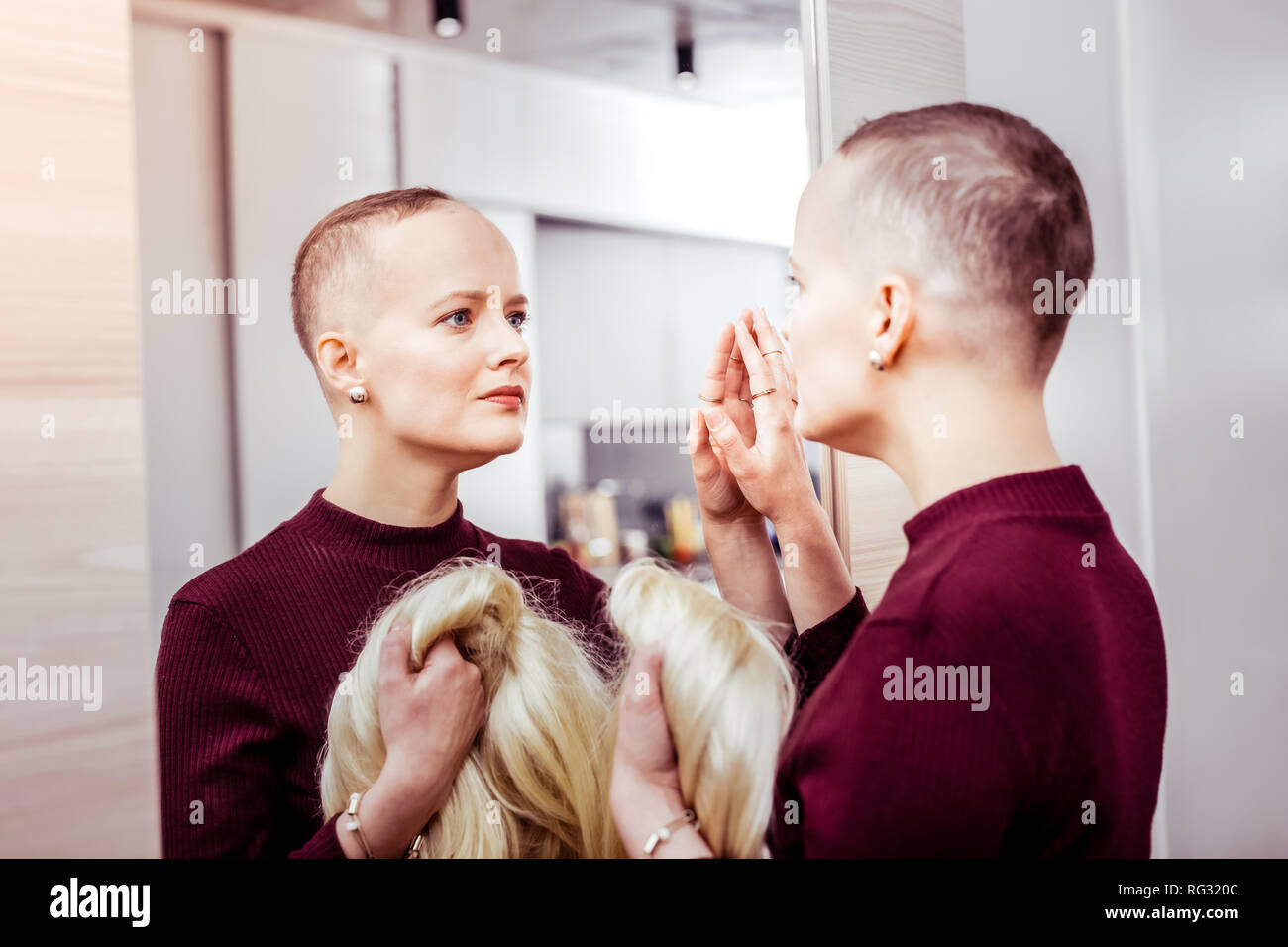 Emotional young woman standing close to mirror Stock Photo - Alamy