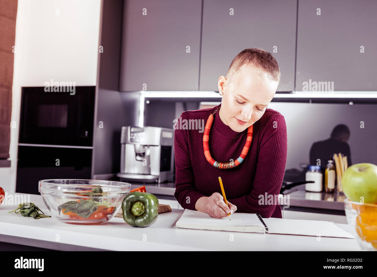 Pleased young woman making her to do list Stock Photo - Alamy