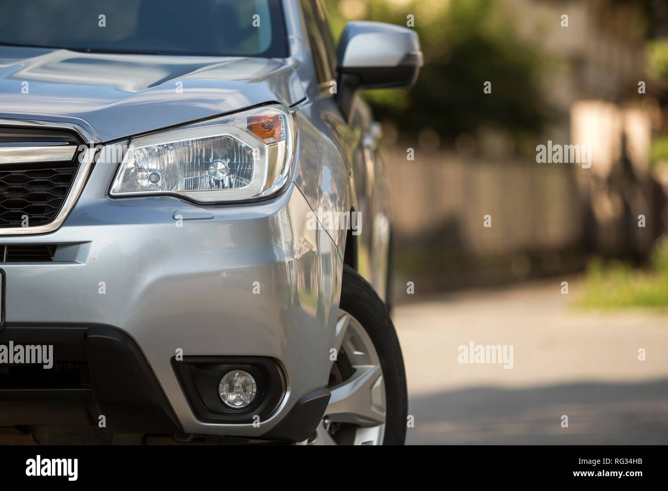 Close-up detail part of silver shiny car-bumper, headlight, wheel and ...