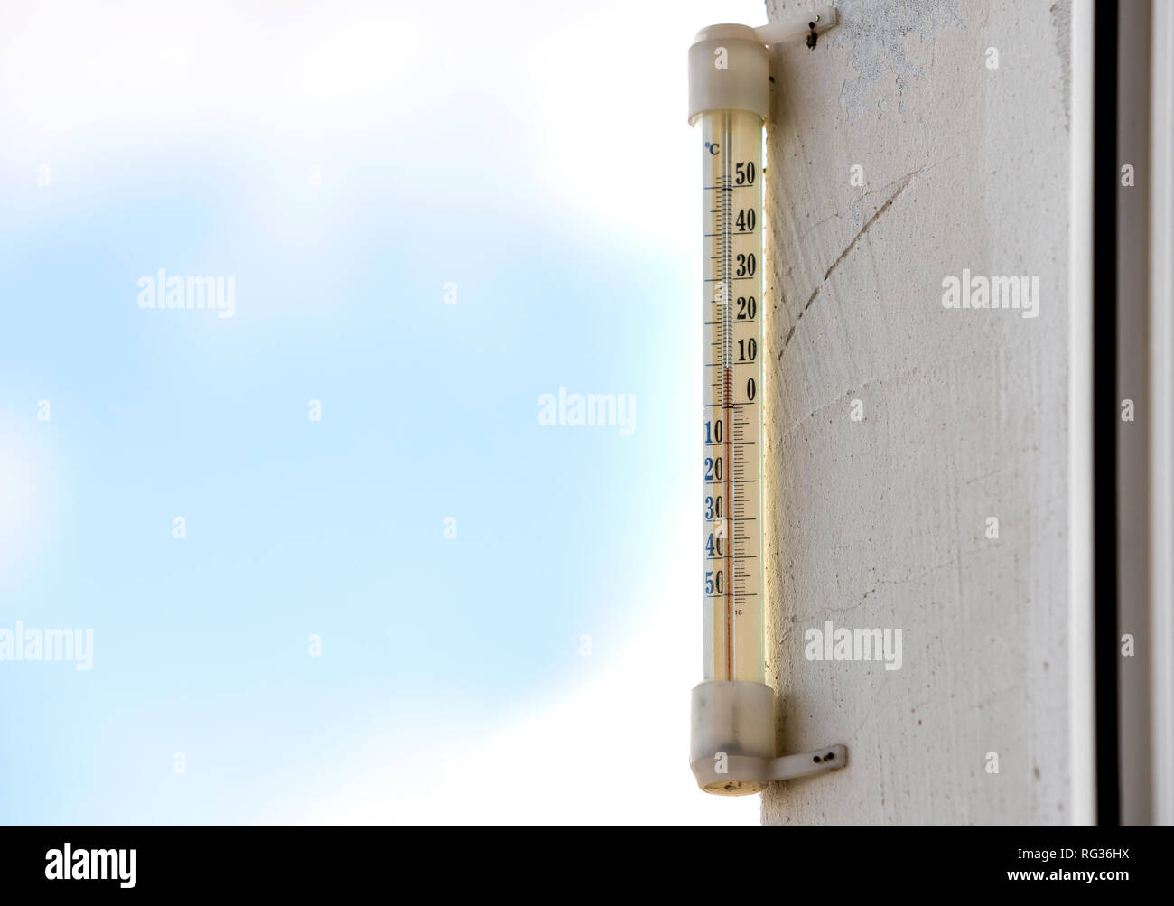 Traditional alcohol glass thermometer Celsius attached to plastered ...