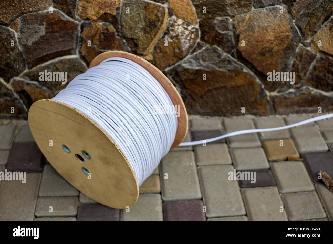 Big roll of white industrial electrical cable on large wooden reel ...
