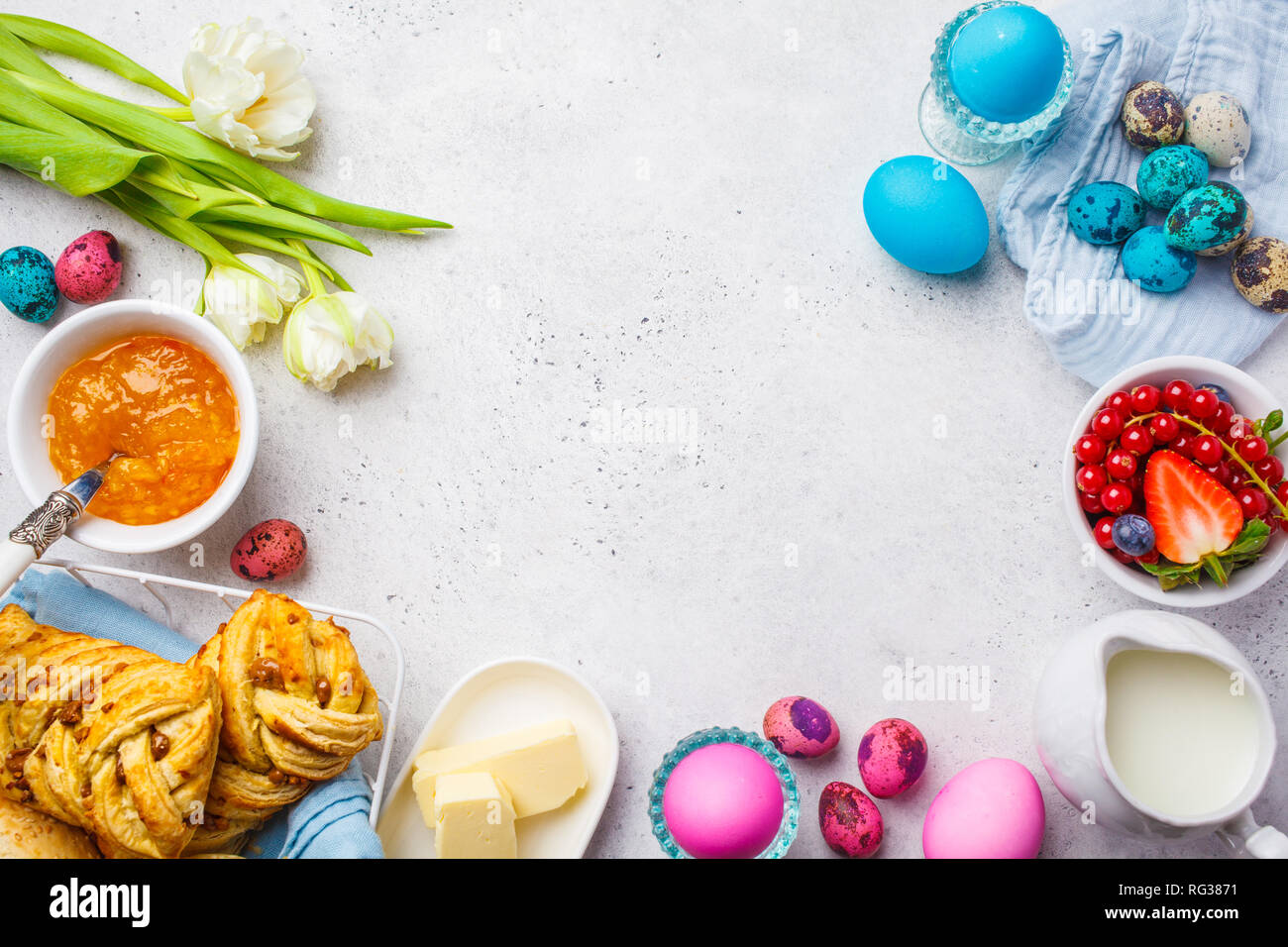 Easter Breakfast table. Colored eggs, flowers, milk, juice and jam ...