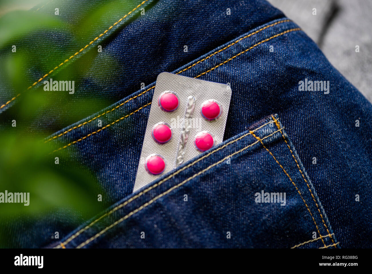 Close up of tablets in blister in jeans pocket. The concept of ...