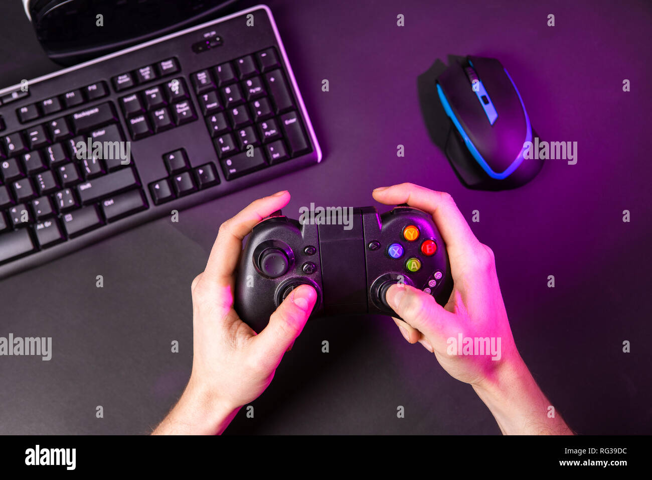 Man hands playing a computer game with a game joystick. Gamer workspace ...