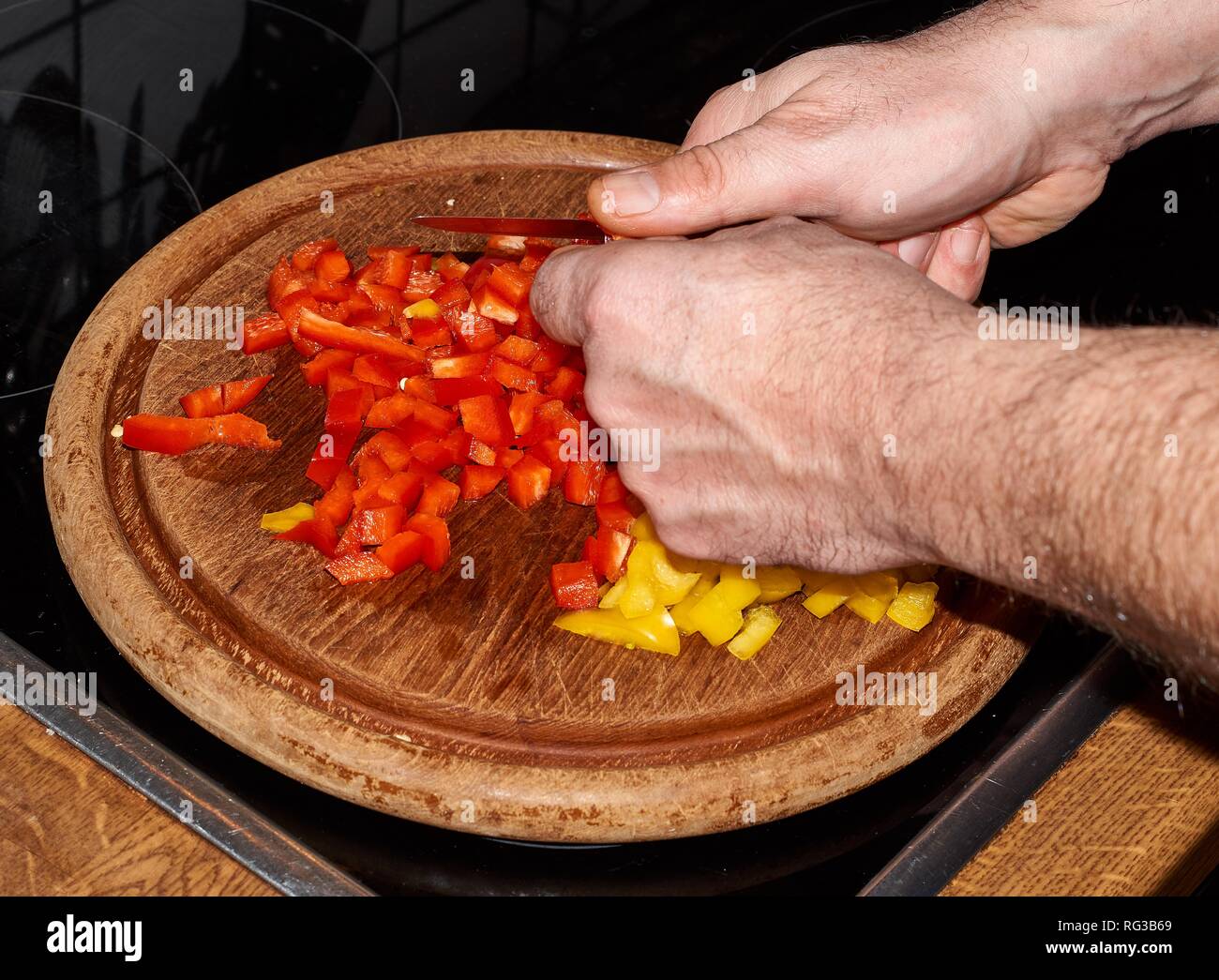 Yellow and red peppers Capsicum cut with a knife on a board Stock Photo ...