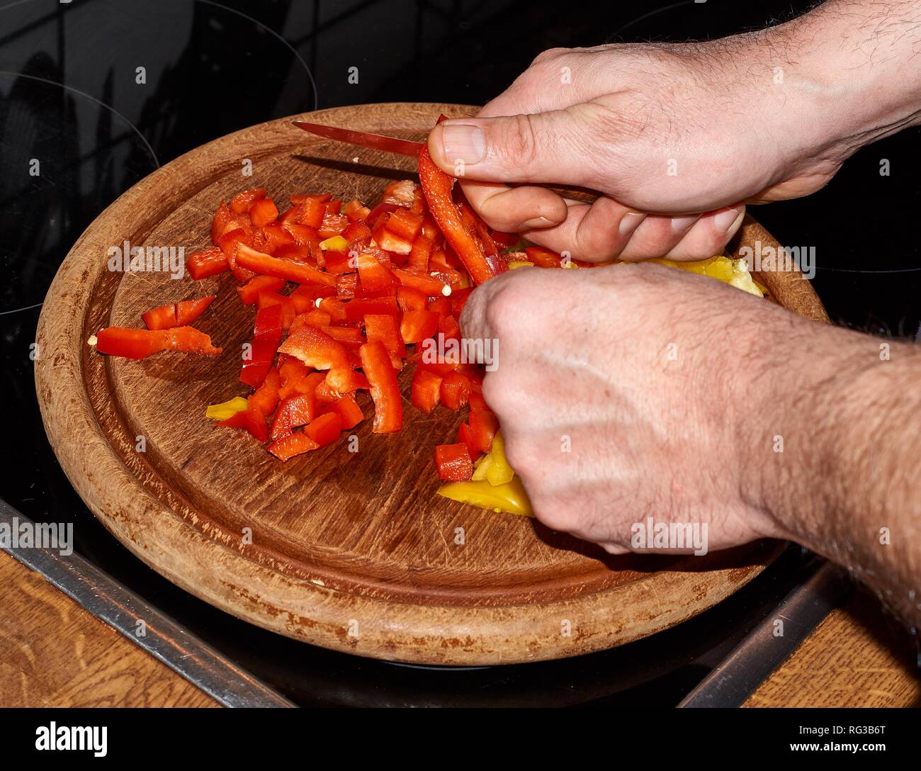 Yellow and red peppers Capsicum cut with a knife on a board Stock Photo ...