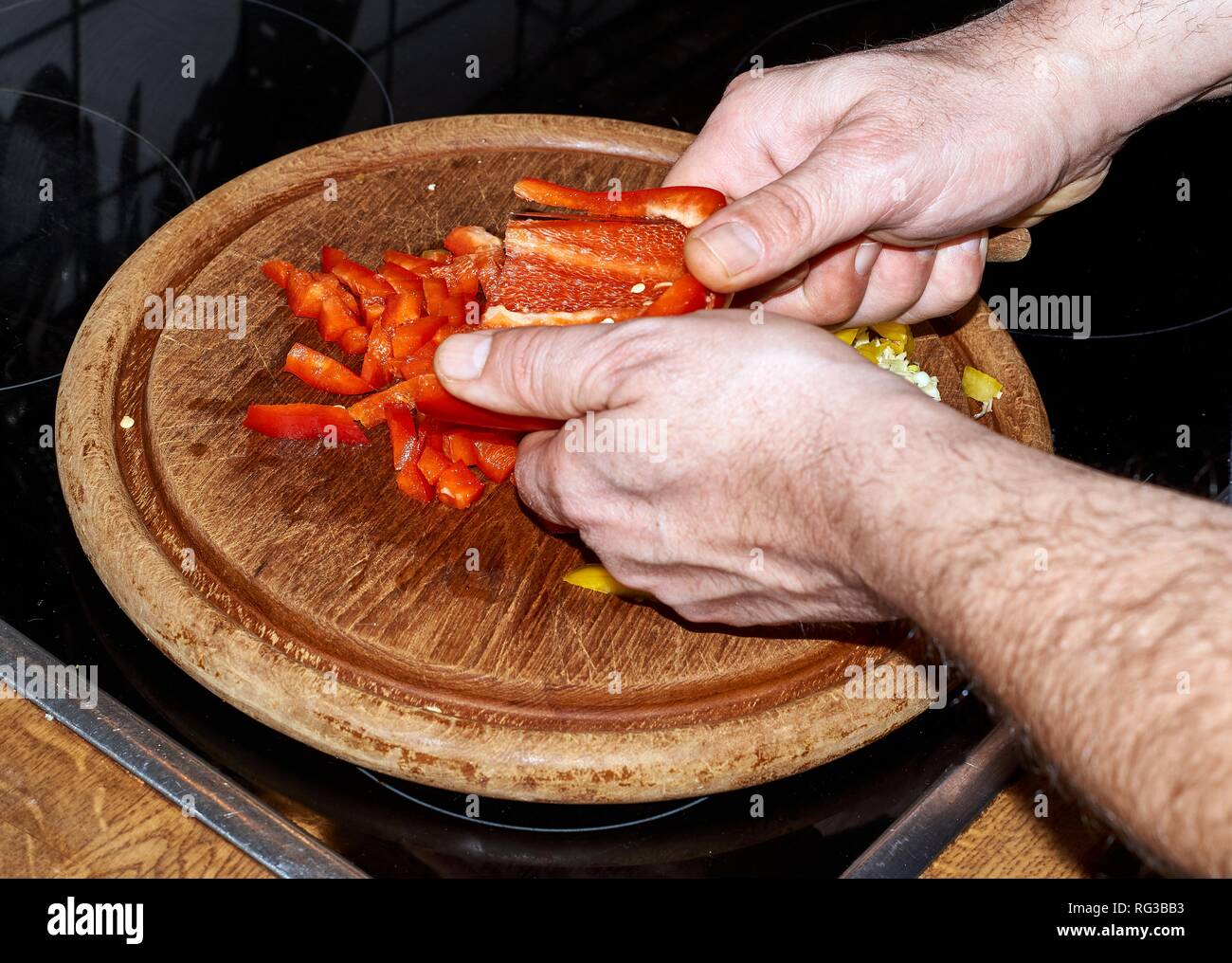 Yellow and red peppers Capsicum cut with a knife on a board Stock Photo ...